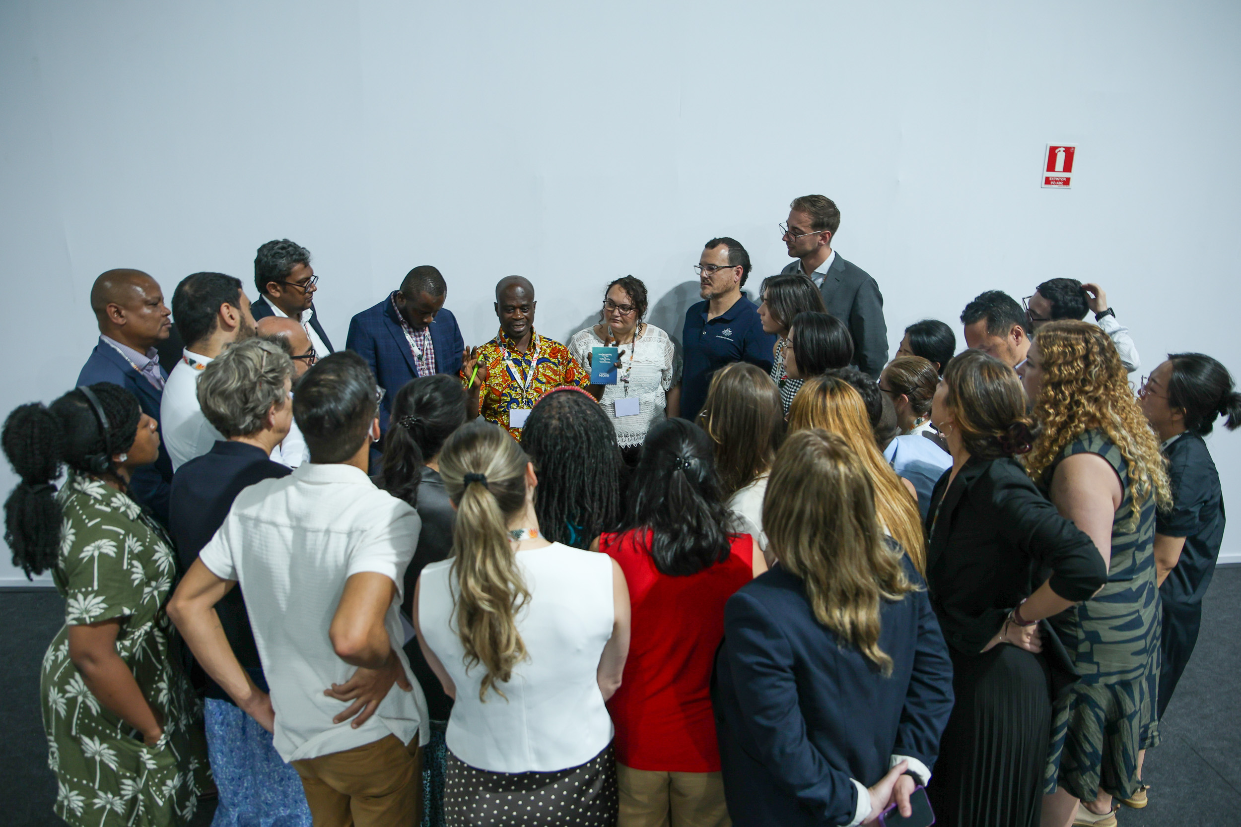 Participants forming a huddle during informal consultations on national ...